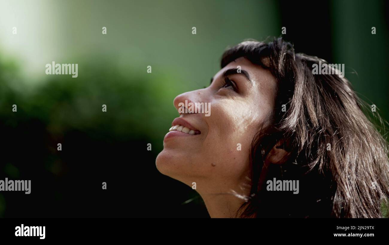 Contemplative young woman looking up at sky with HOPE and FAITH ...