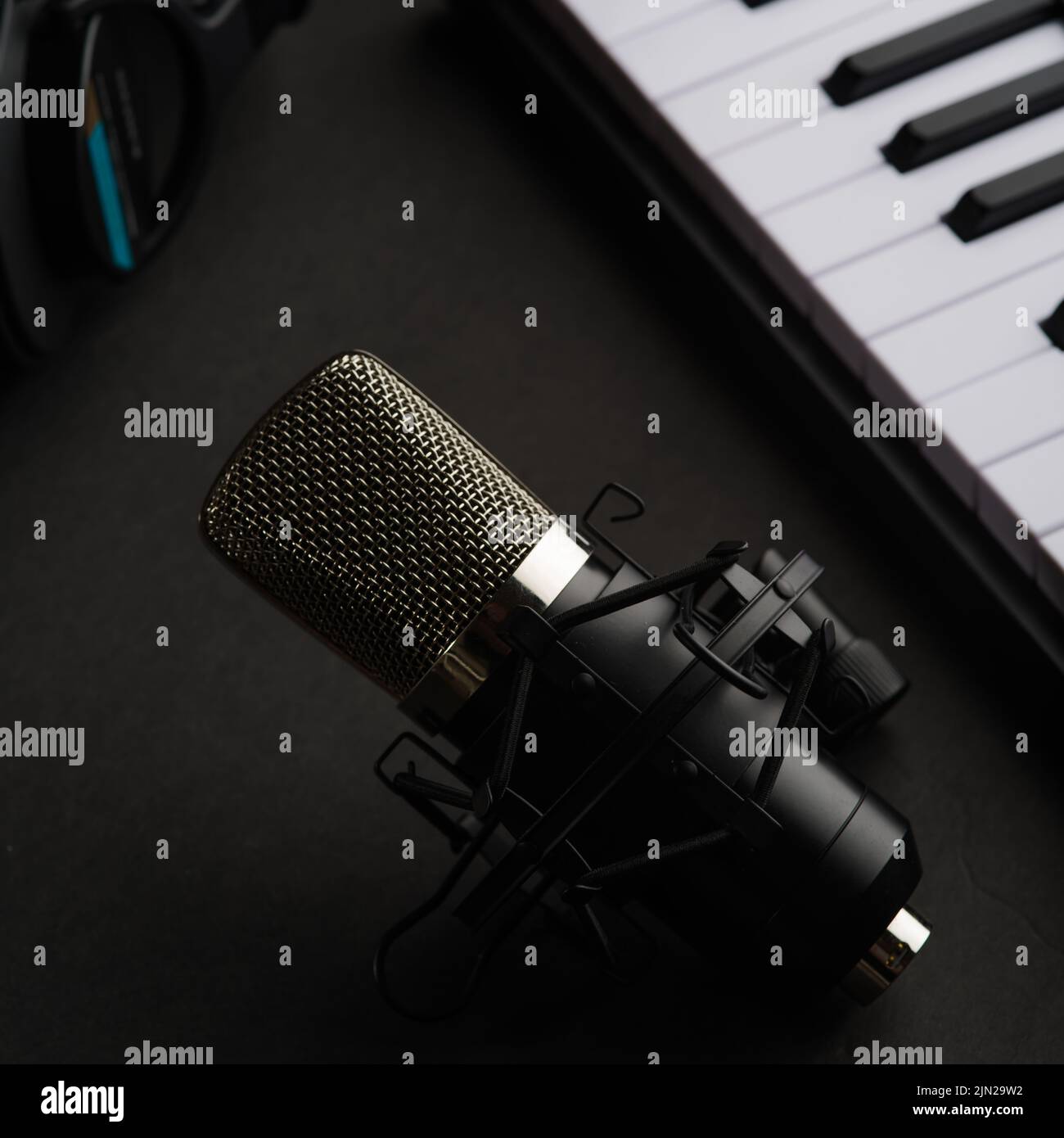 Studio microphone, studio headphones and midi keyboard on a gray ...