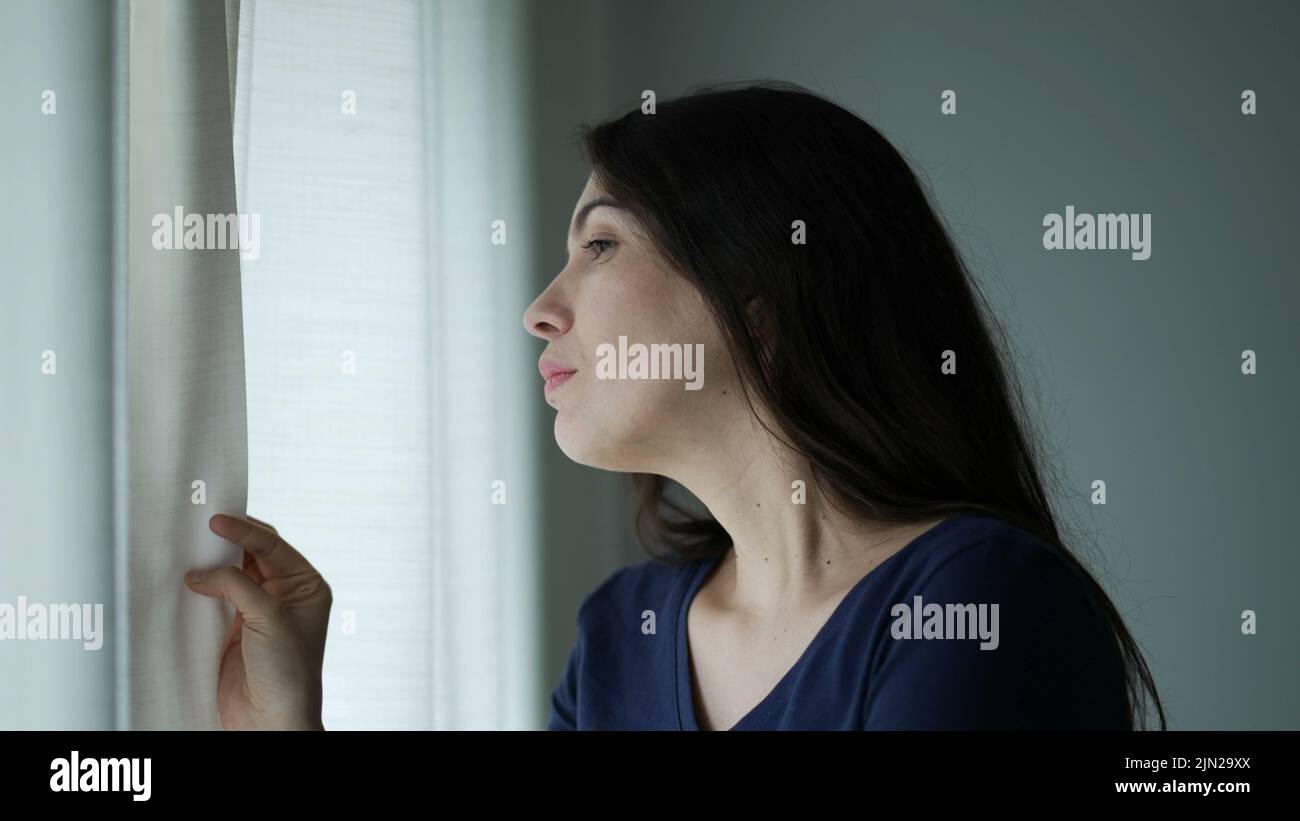 Woman peeking through curtains hi-res stock photography and images - Alamy