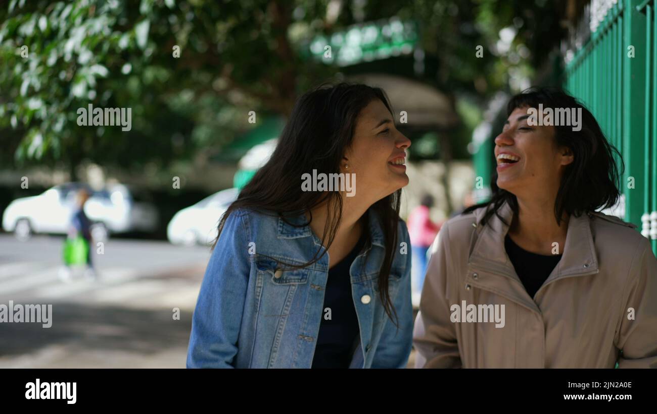 Two happy female friends natural authentic laugh and smile in city ...