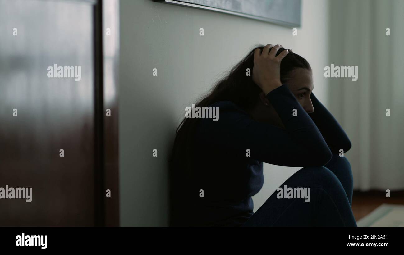 Woman feeling emotional pain sitting on floor home being desperate ...