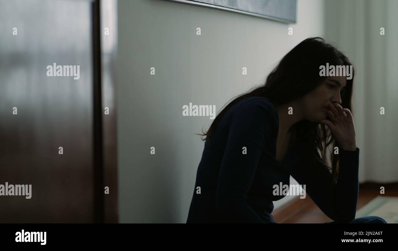 Woman feeling emotional pain sitting on floor home being desperate ...