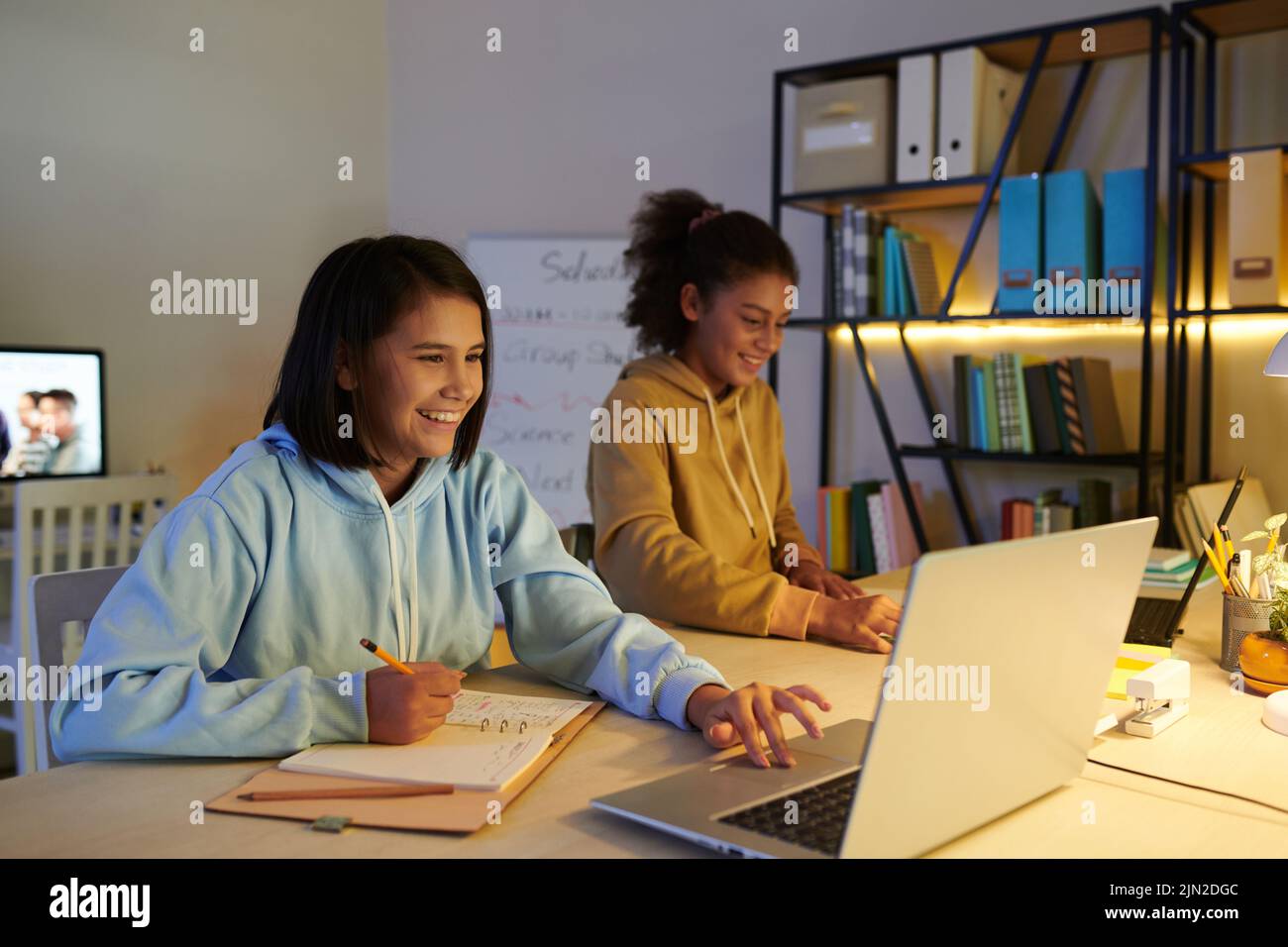 Friends enjoying doing homework together at home for upcoming class ...
