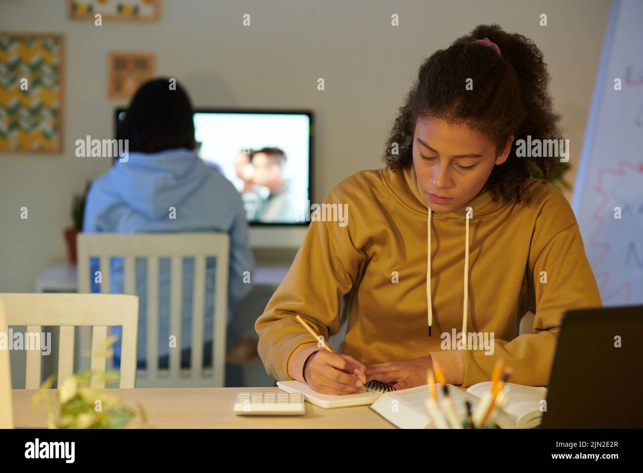 Serious high school student writing in notepad when planning work on ...