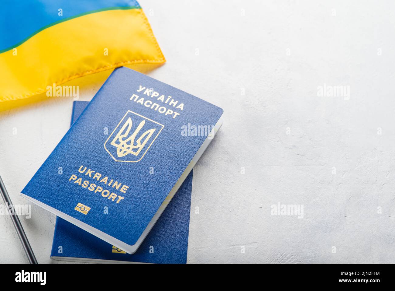 On a white background are two biometric Ukrainian passports and a small ...