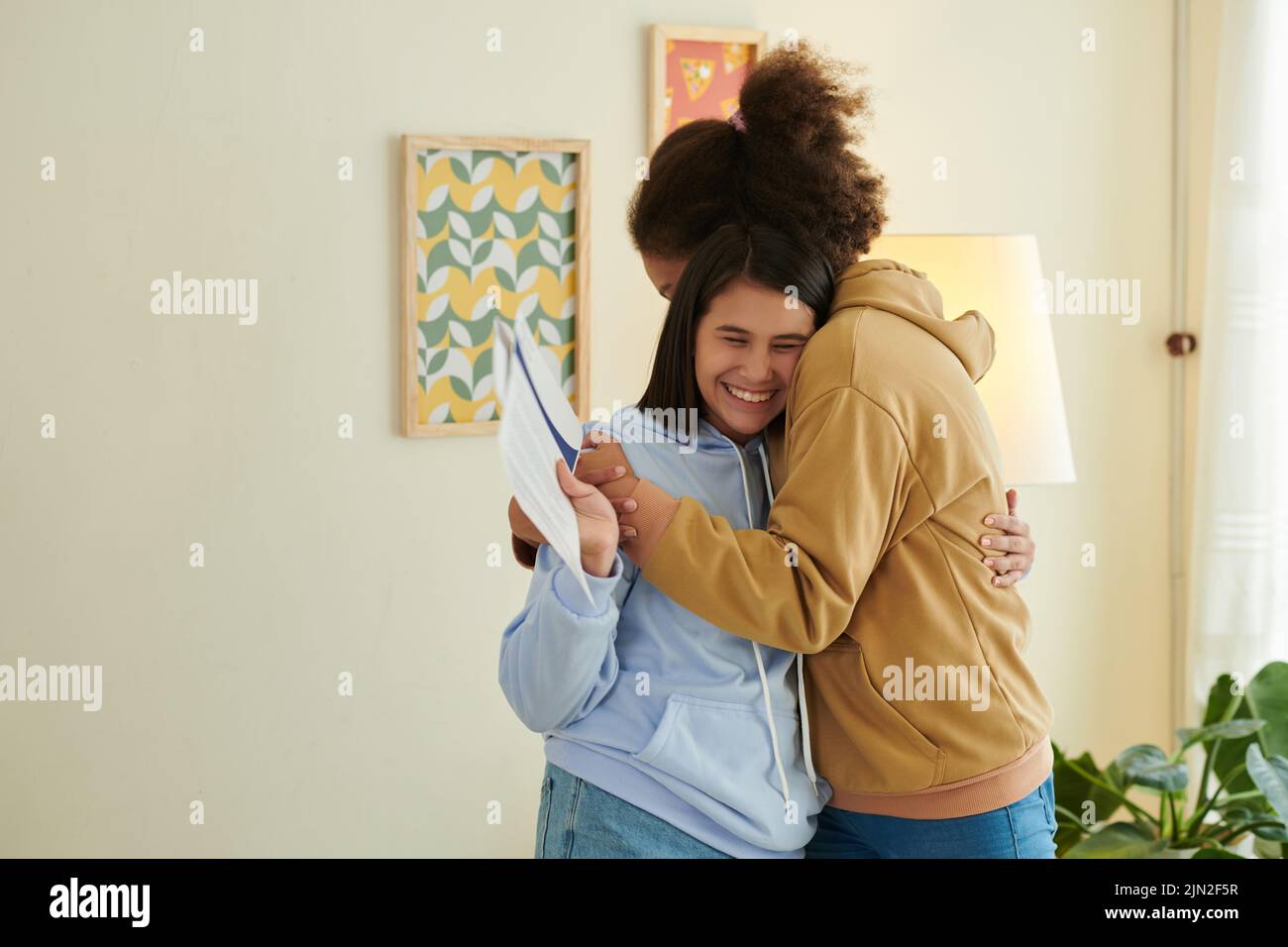 Teenage girl hugging her friend received acceptance letter from ...