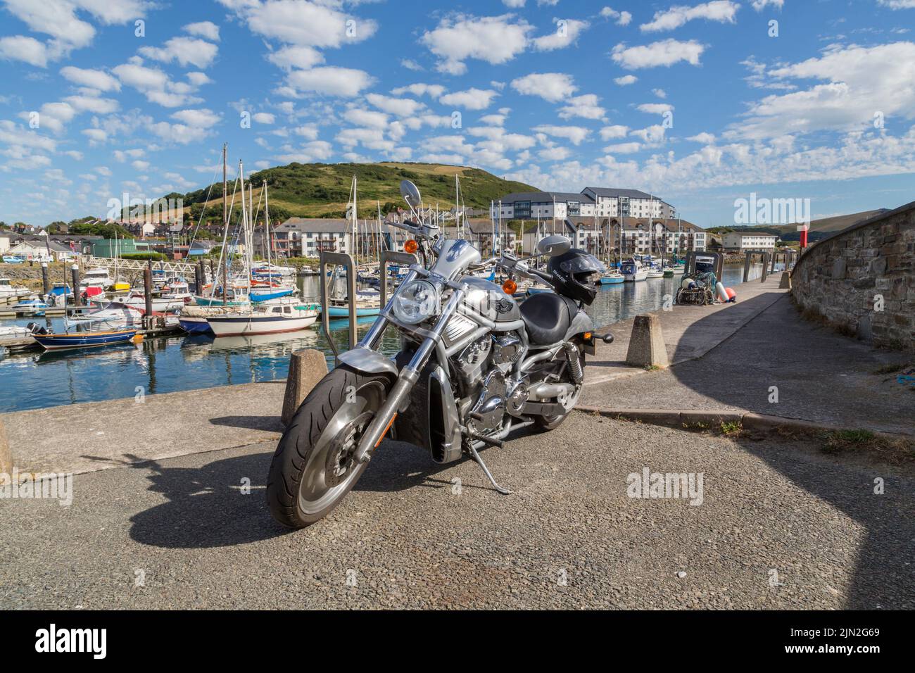 A Harley Davidson motorcycle on side stand with sailing boats in a ...
