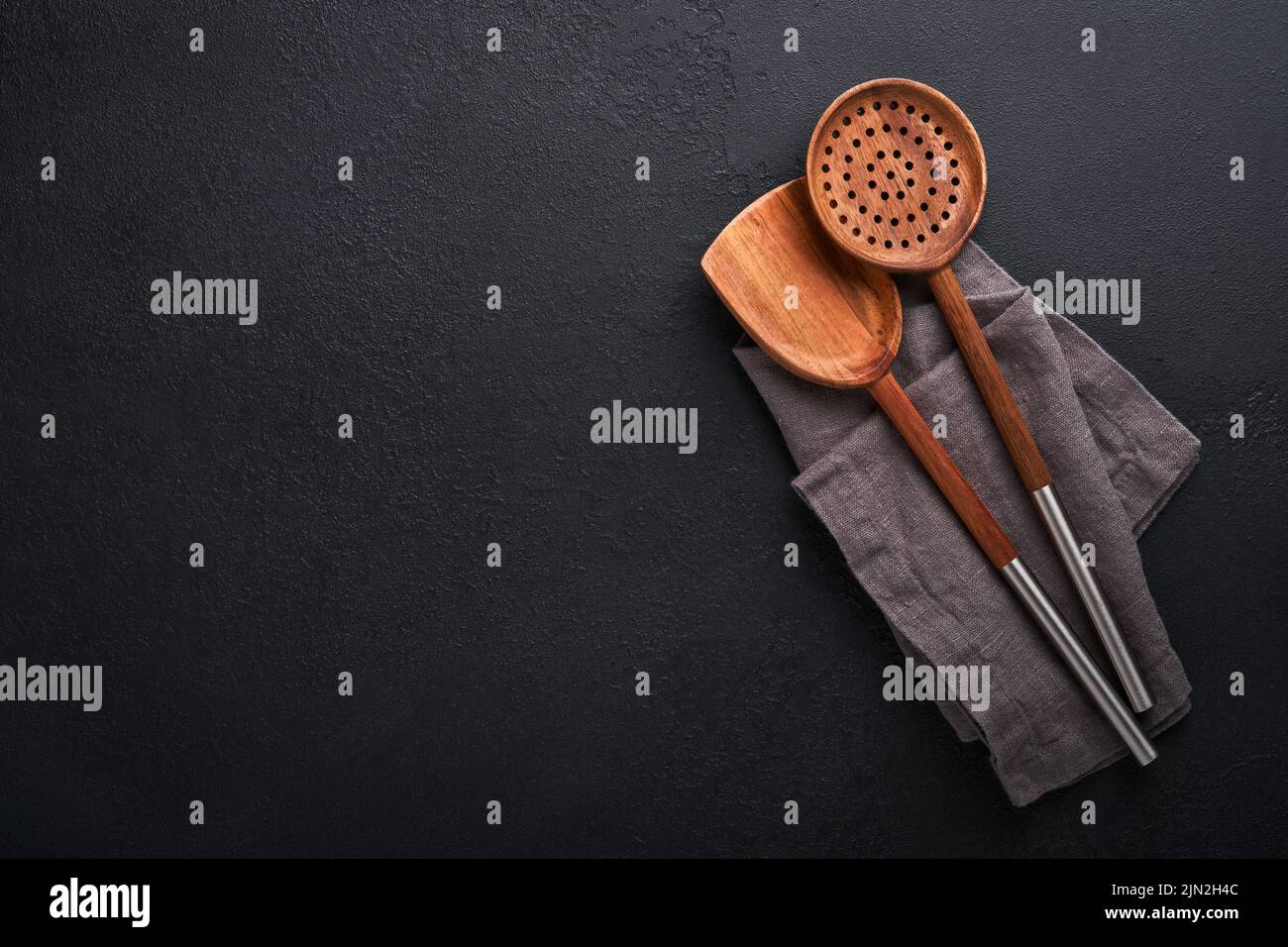 Cooking wooden utensils, basil leaves and spices on dark stone ...