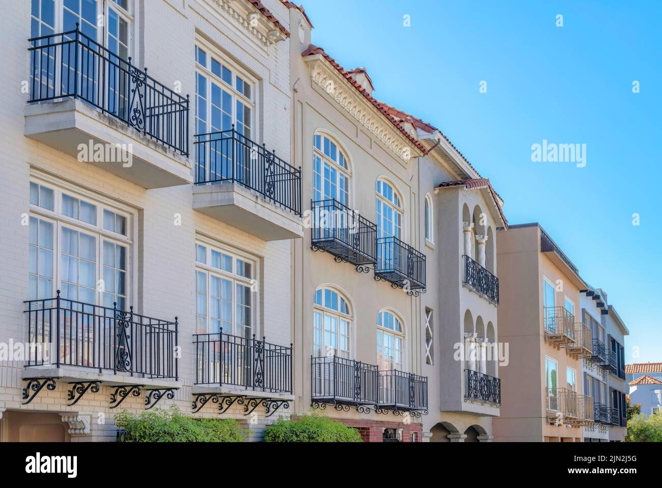 Row of mediterranean houses with wrought iron railings on its window ...
