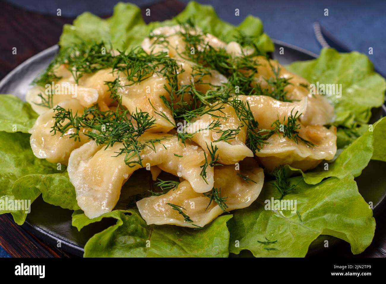 Delicious fresh cooked dumplings with potatoes embellished with greens ...