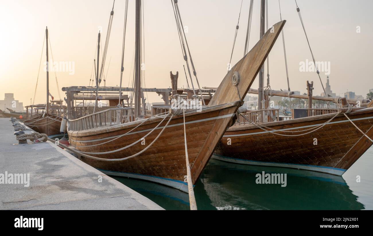 Multiple wooden traditional fishing dhows docked in the doha corniche ...