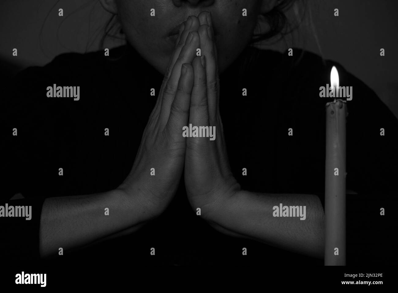 A young Ukrainian girl prays near a candle for Ukraine in Ukraine, a ...