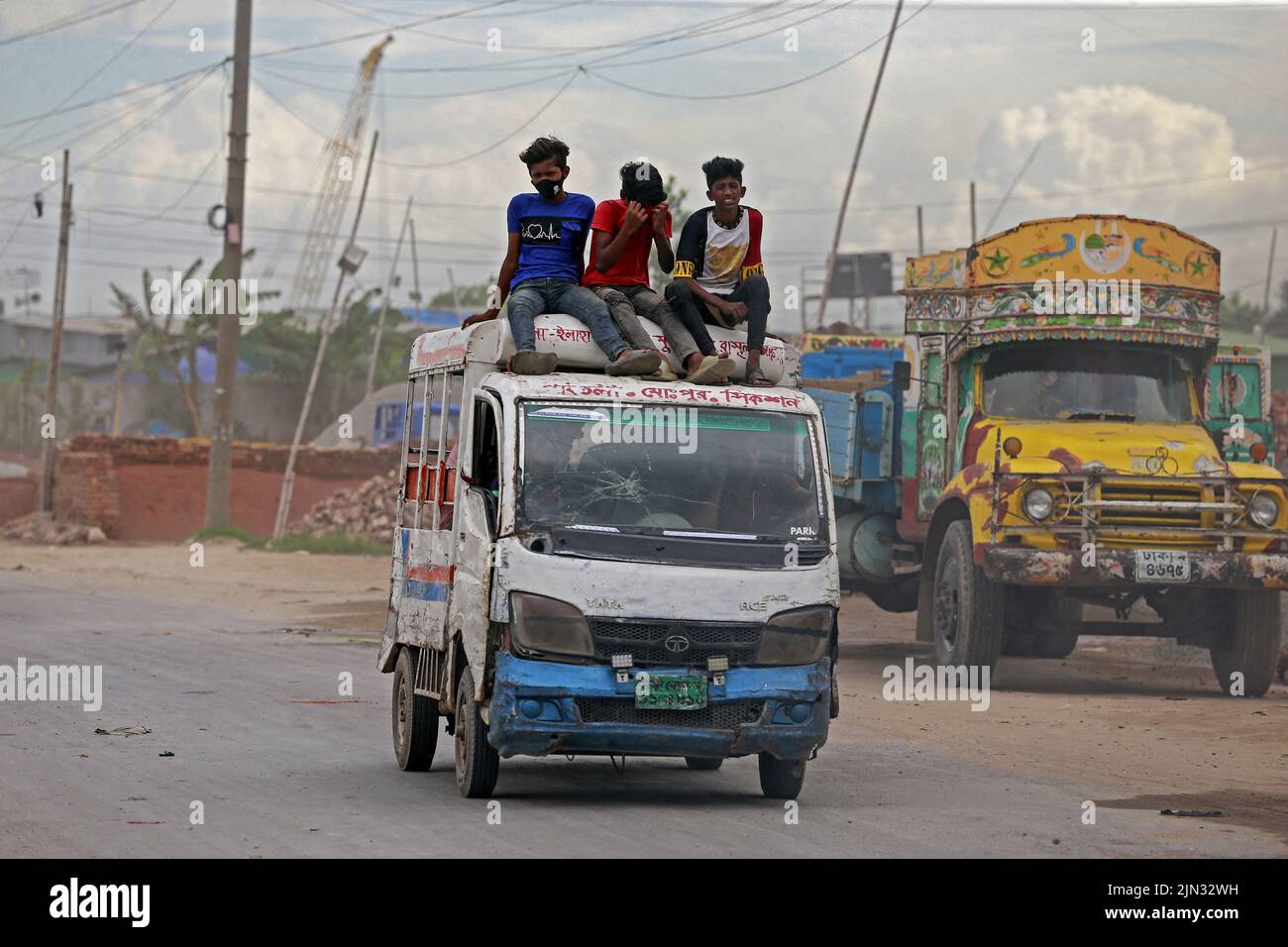 Dhaka, Bangladesh, August 8, 2022. Children sit on the roof of a human ...