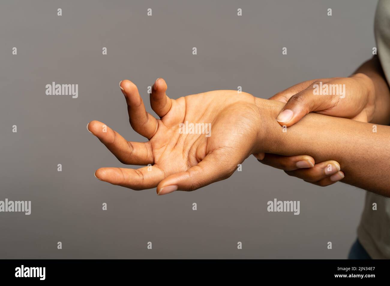 Black female arms massaging painful wrist suffering from weakness and ...