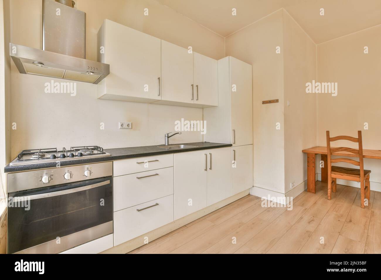Interior of empty white kitchen with corridor and wooden parquet floor ...