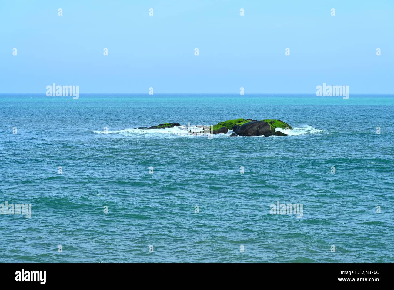 Black rock in the middle of the ocean Stock Photo - Alamy