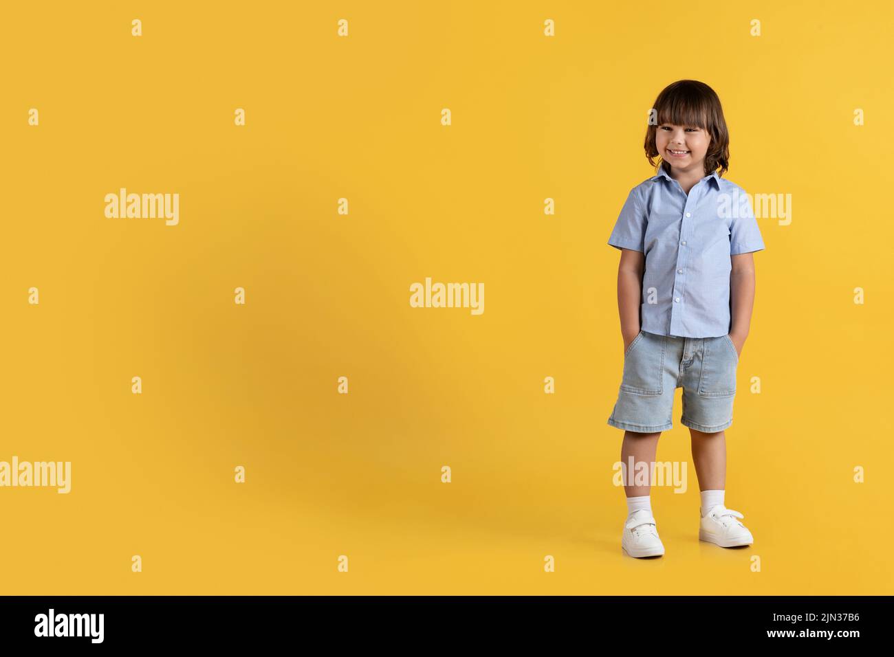 Special offer for kids. Adorable little boy with hands in pockets ...