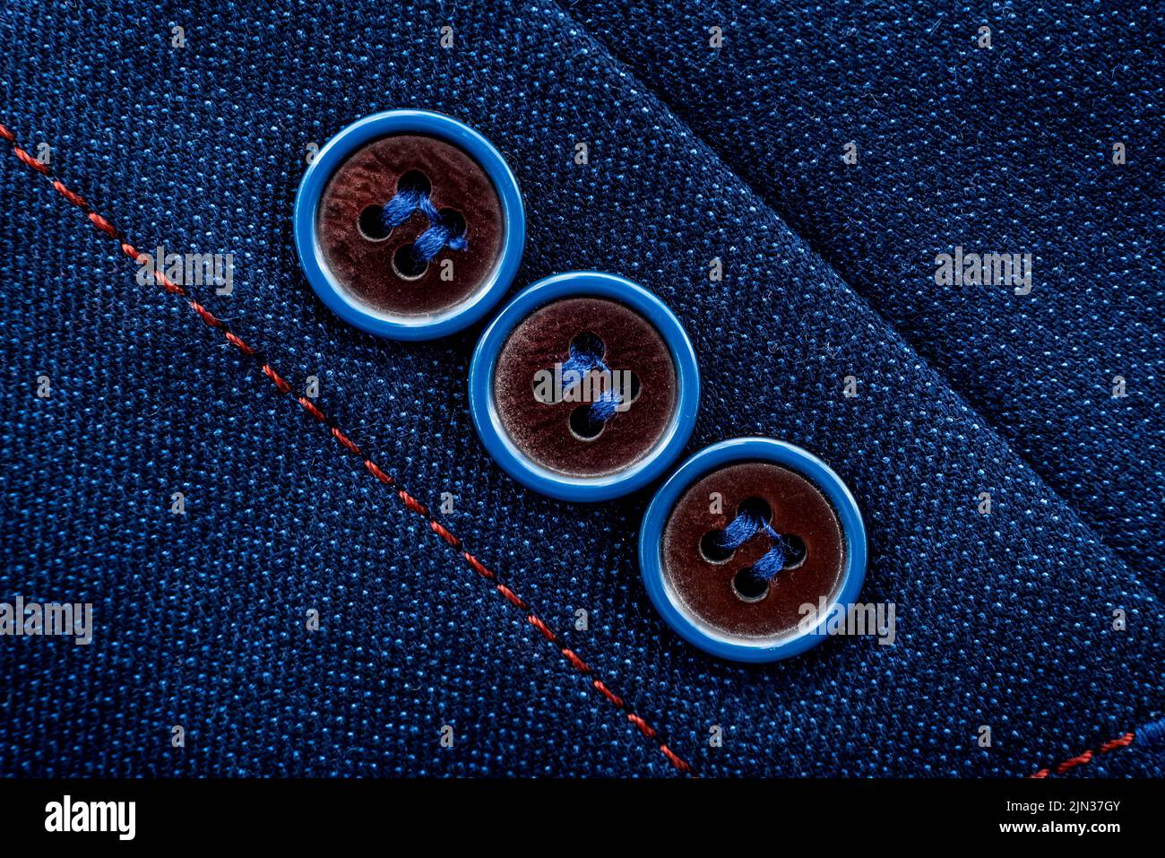 A row of buttons on the sleeve of a blue men's suit. clothing element ...
