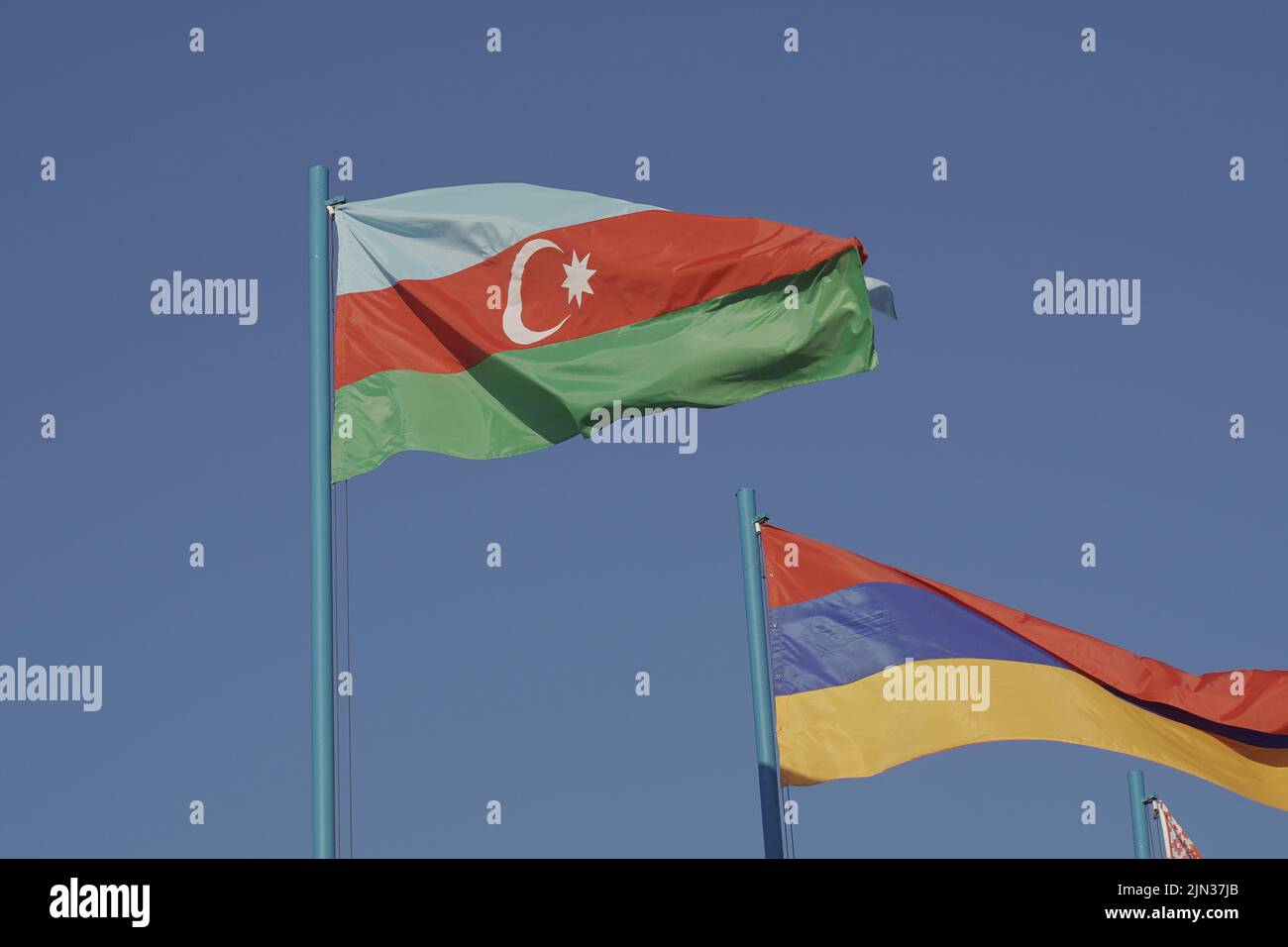 The national flags of Azerbaijan and Armenia are fluttering in the wind ...