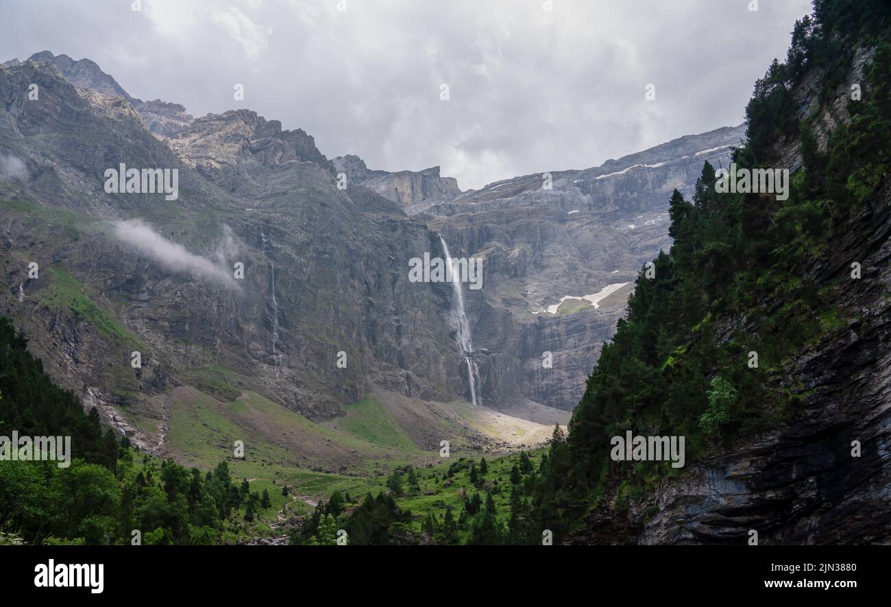 large waterfalls on steep mountain cliffs, low cloud in the valley ...
