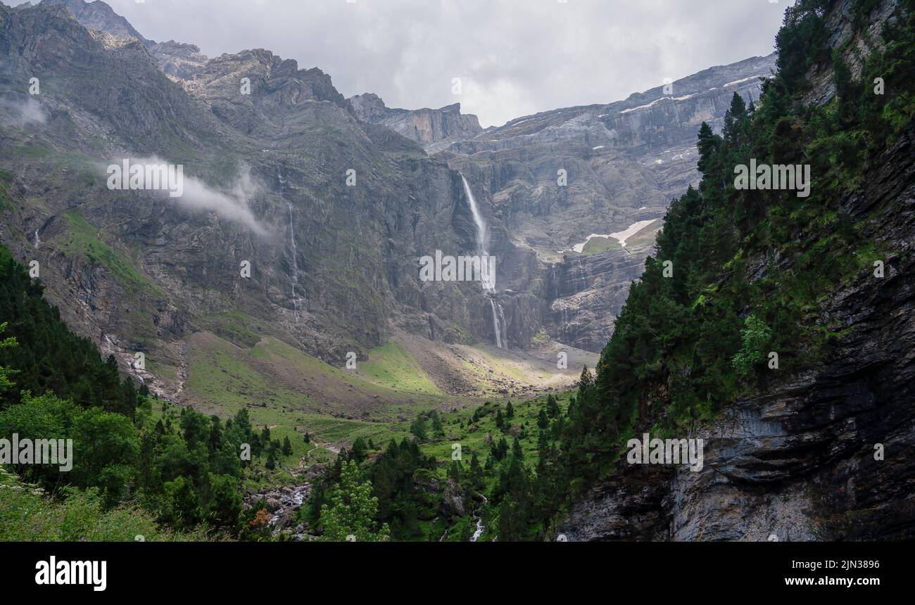 large waterfalls on steep mountain cliffs, low cloud in the valley ...
