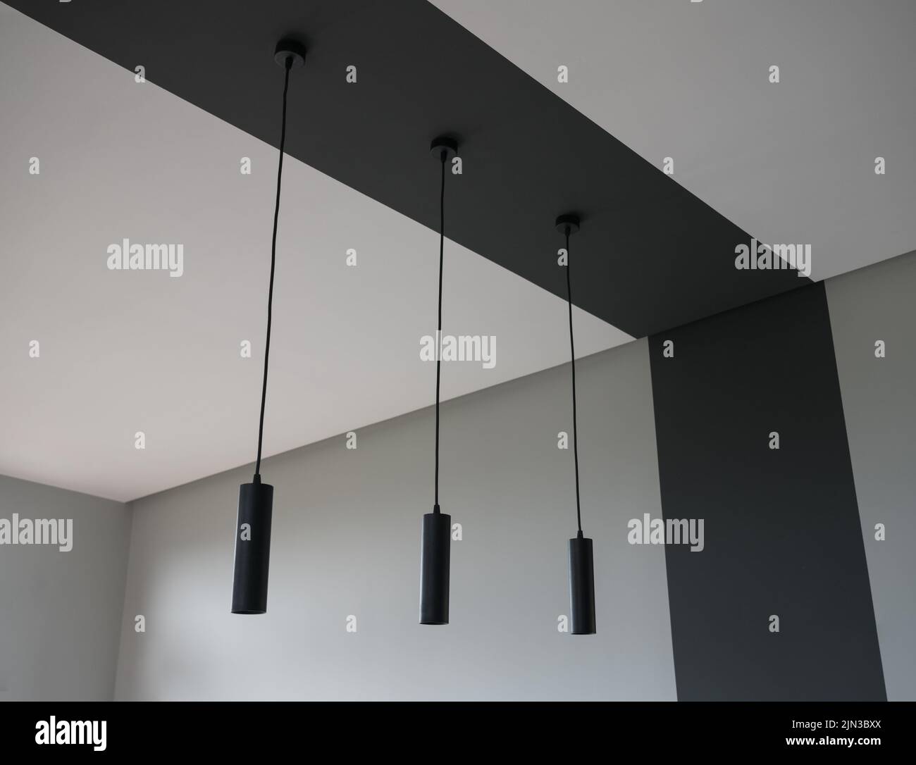 Three black modern bar lights hanged on black ceiling Stock Photo - Alamy