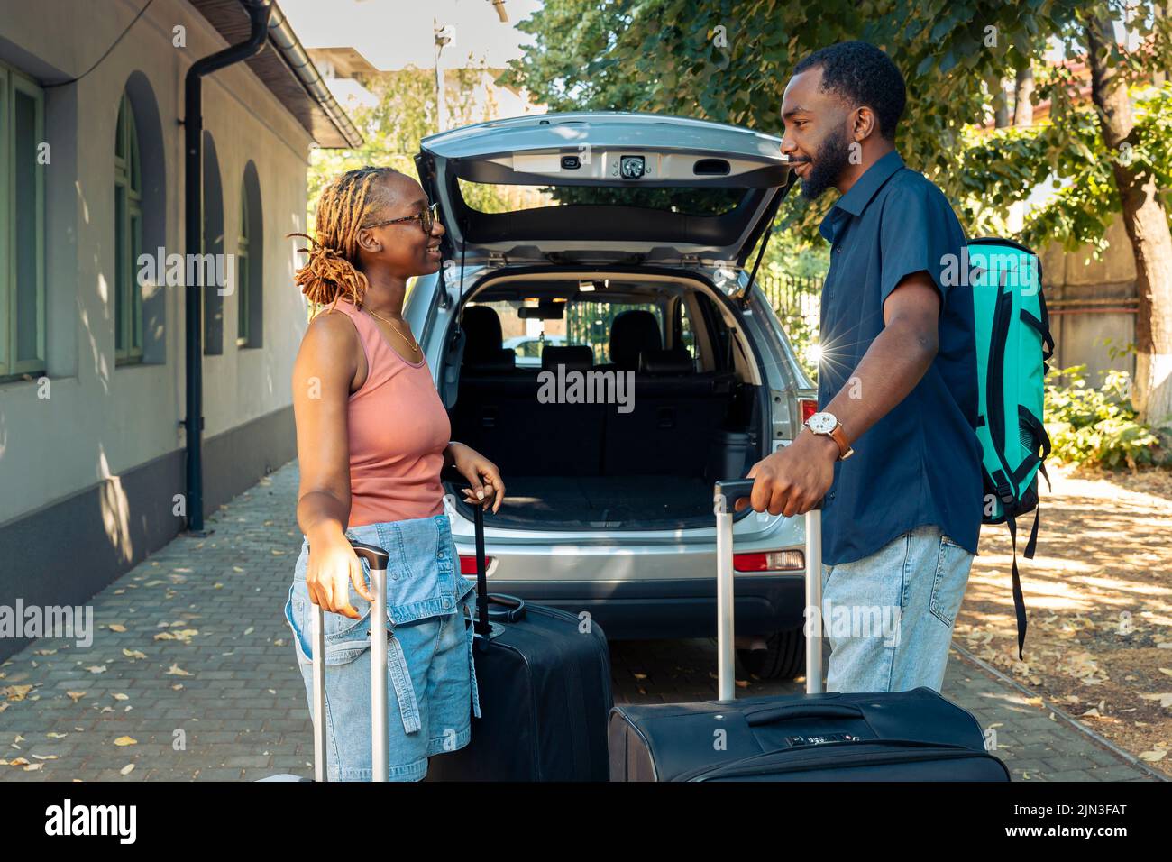 African american couple loading baggage in trunk, leaving together on ...