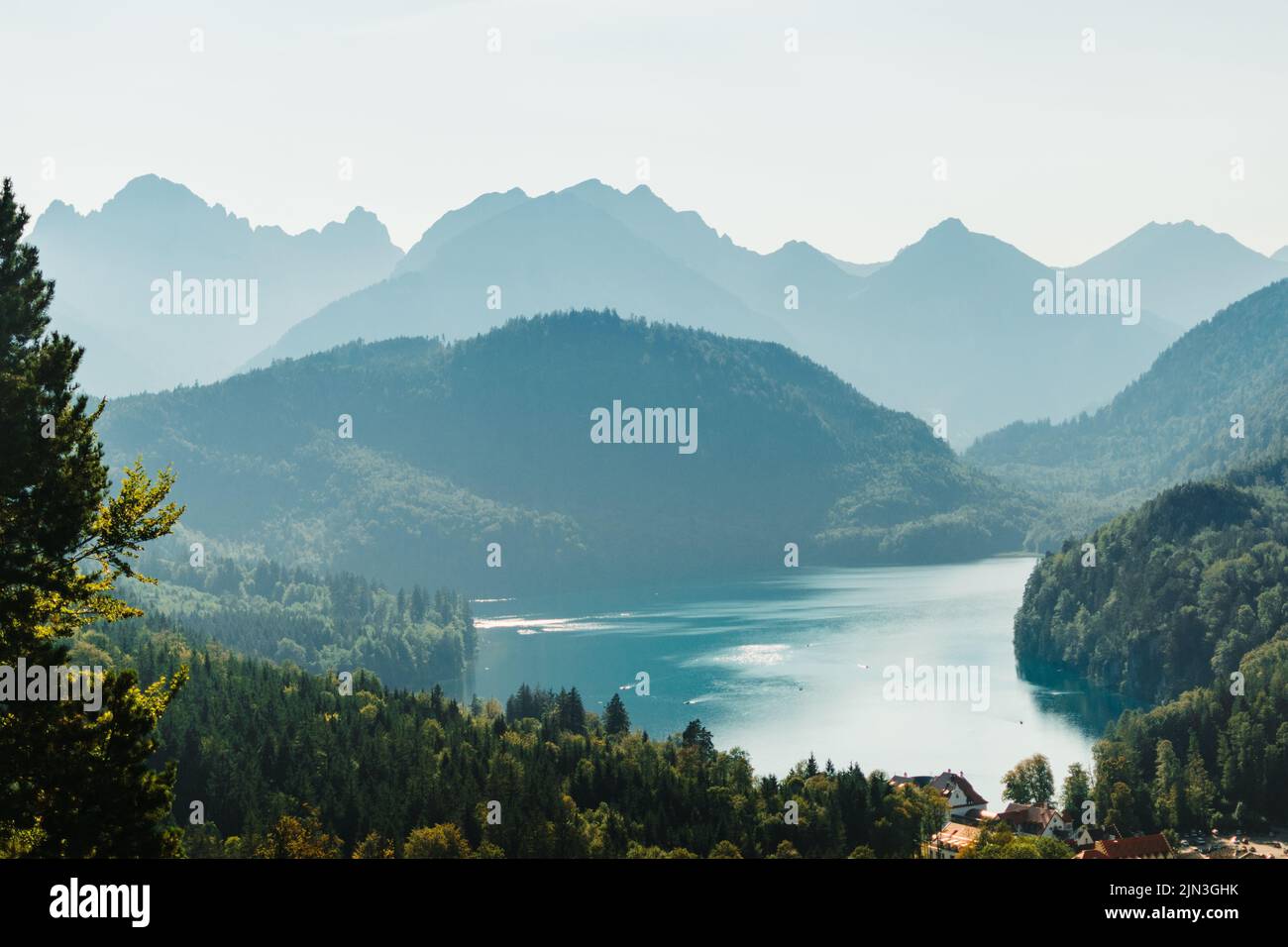 A beautiful scenery of a lake surrounded by greenery, cliffs and ...