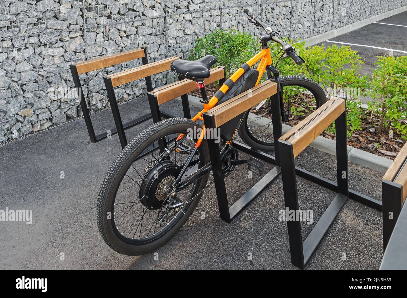 Electric mountain bike parked in public bicycle rack next to granite ...