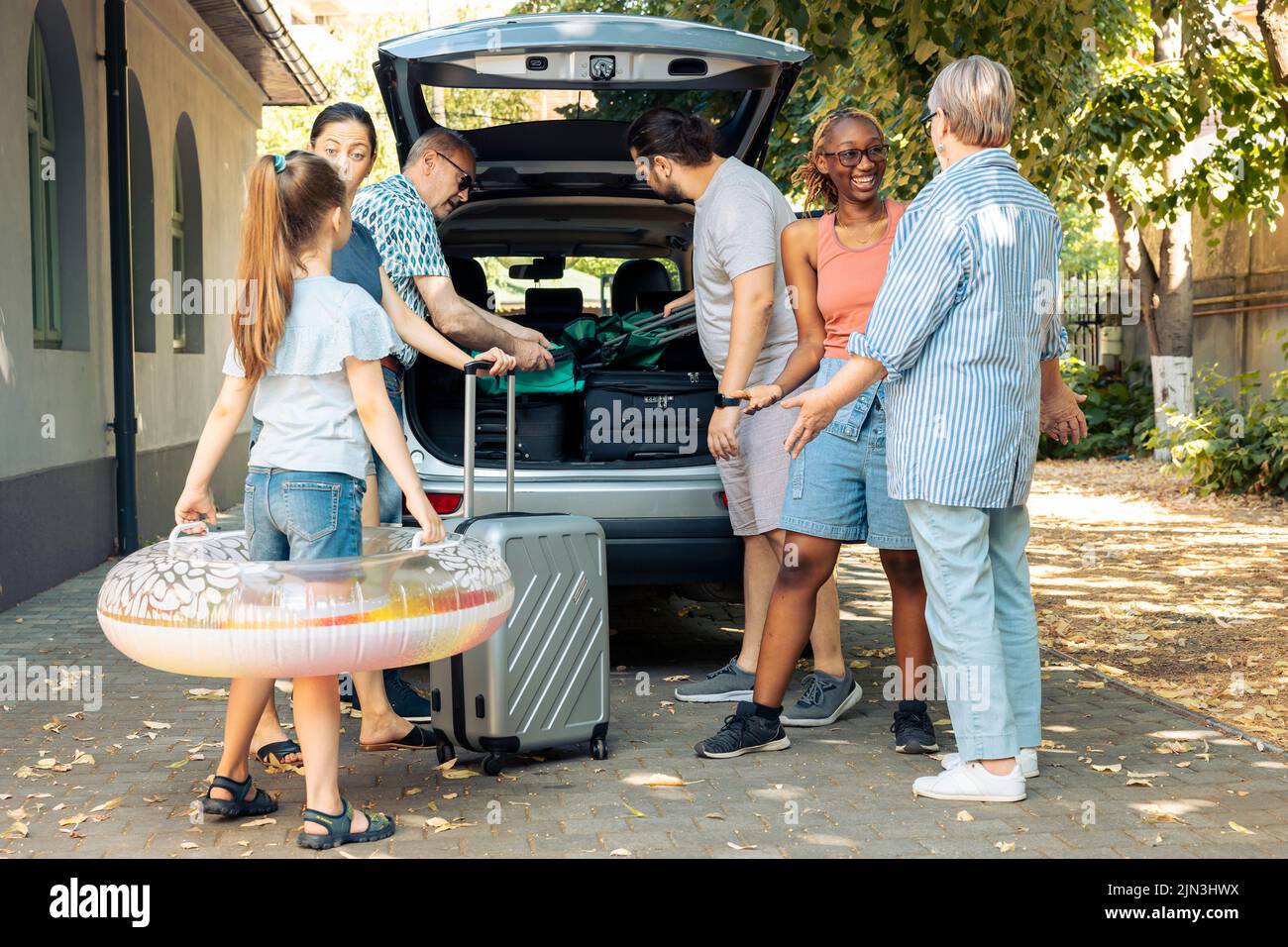 Multiethnic family and friends travelling on vacation, preparing to ...