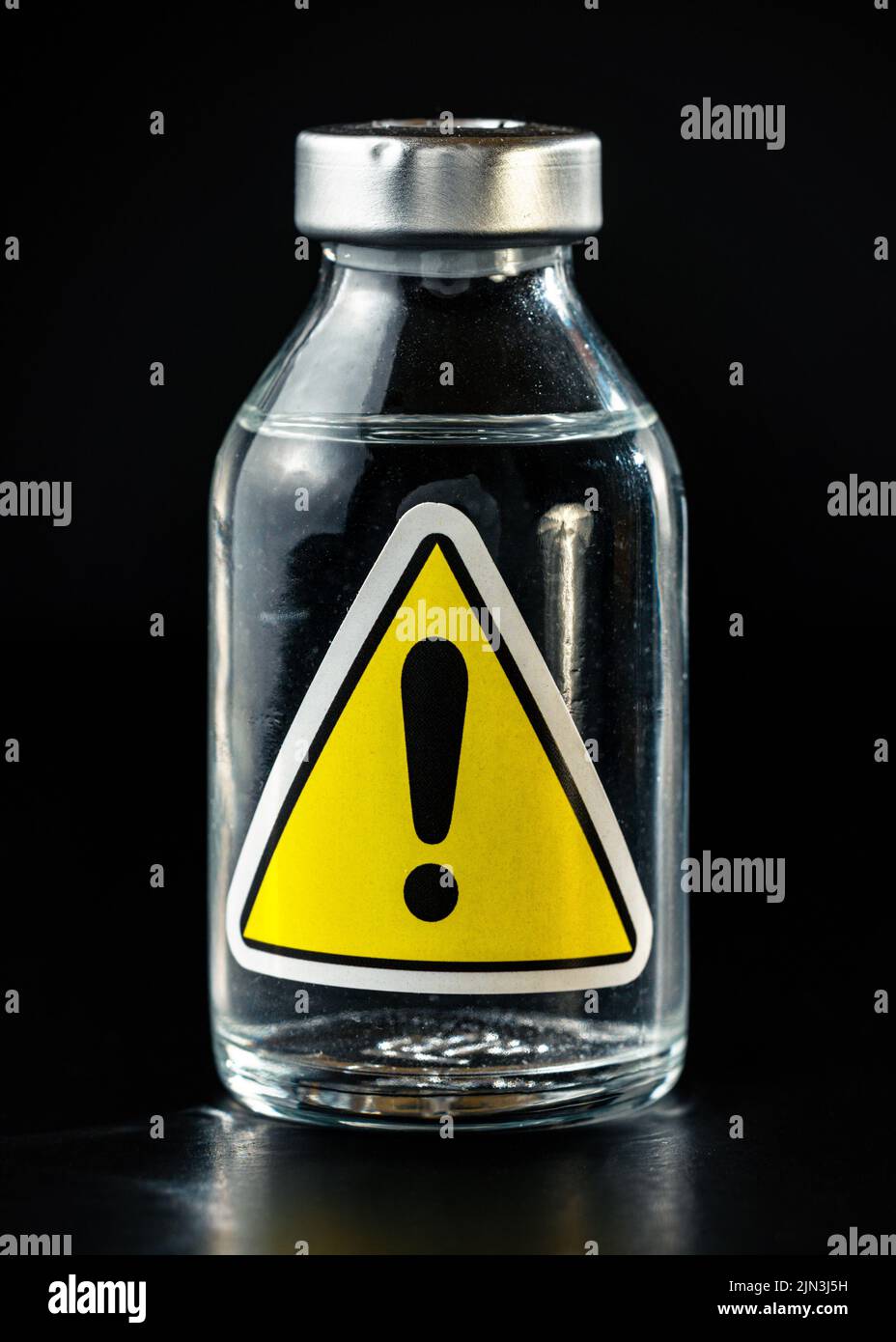 Vaccine bottle with yellow triangle exclamation mark sign on label ...