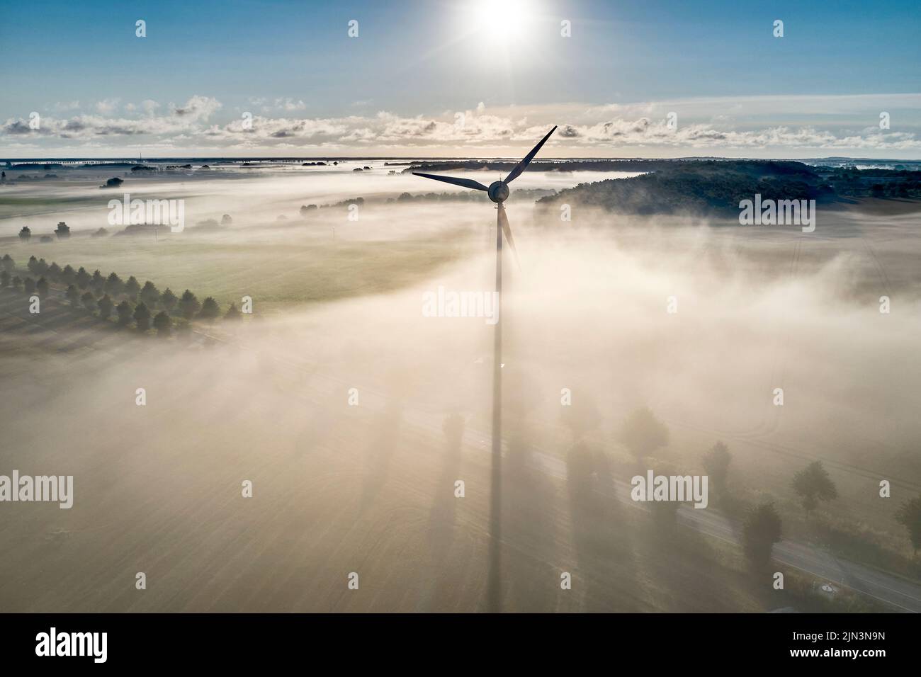 onshore wind turbine standing in fog in the morning sun Stock Photo - Alamy