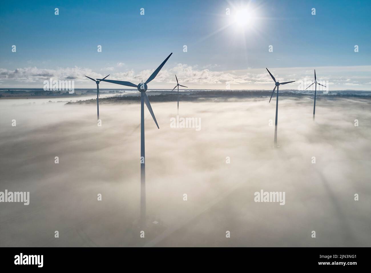 onshore wind turbine standing in fog in the morning sun Stock Photo - Alamy
