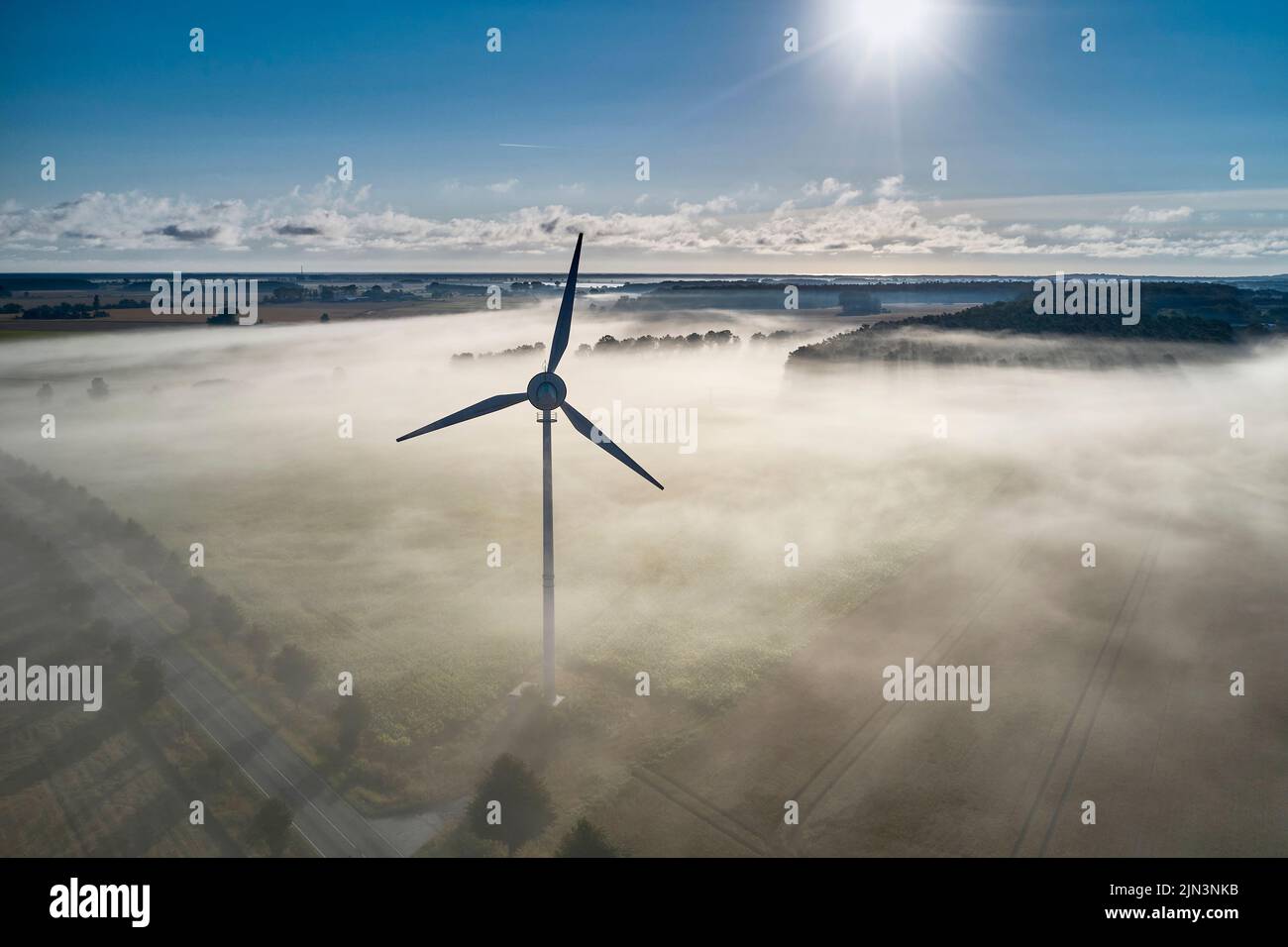 onshore wind turbine standing in fog in the morning sun Stock Photo - Alamy