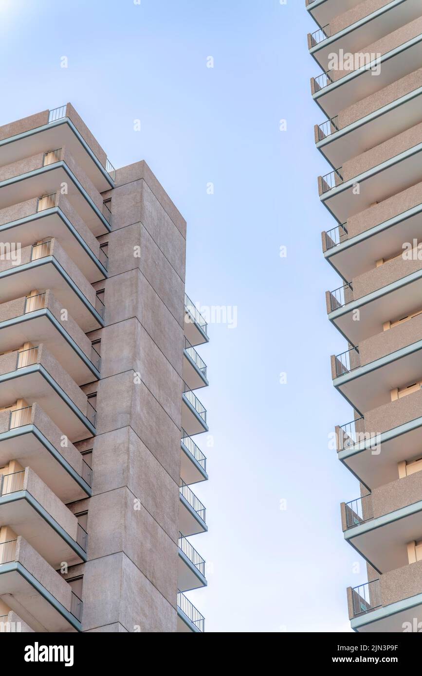 Two identical buildings with concrete wall claddings and hallway ...