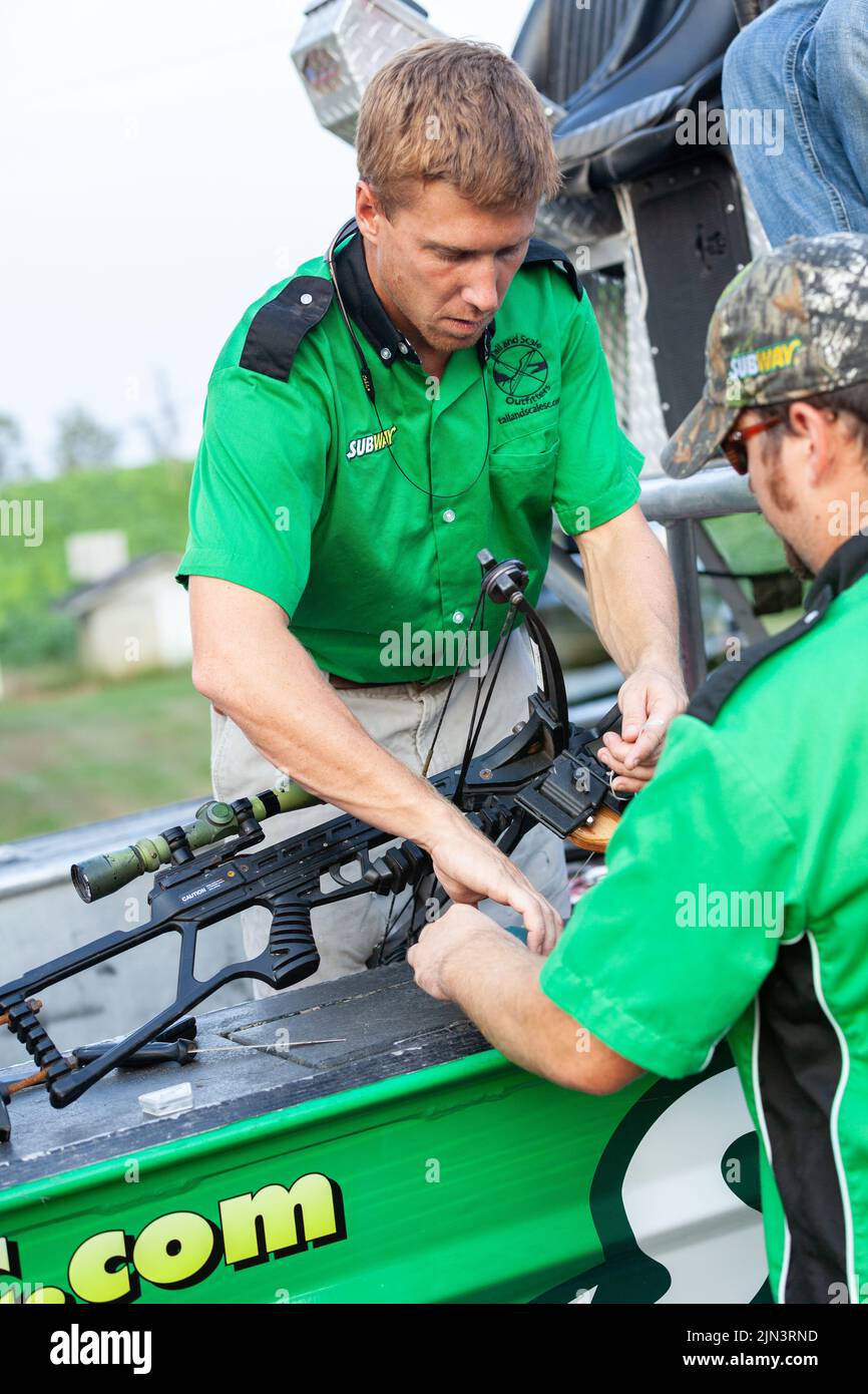 Hunting guides prepare a crossbow on their airboat before a nighttime ...