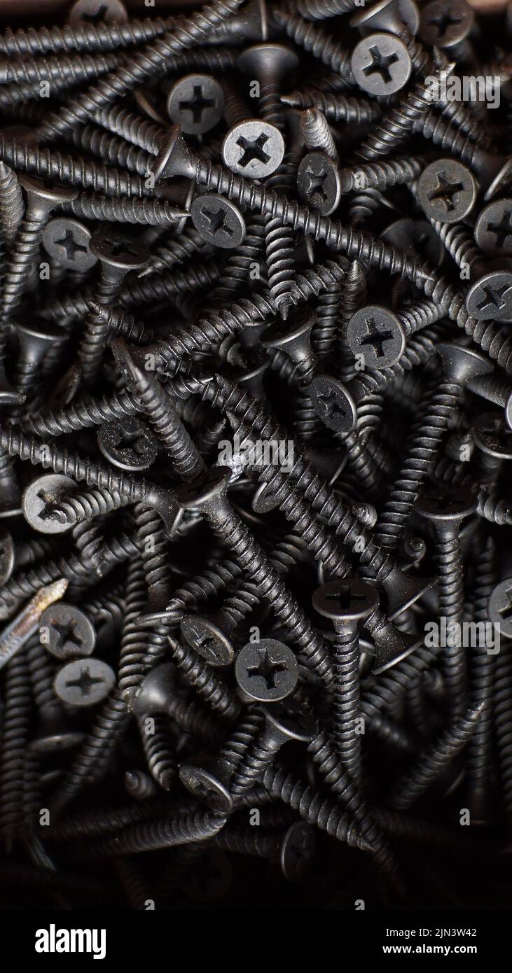 Small wood screws in large quantities. texture of black screws top view ...