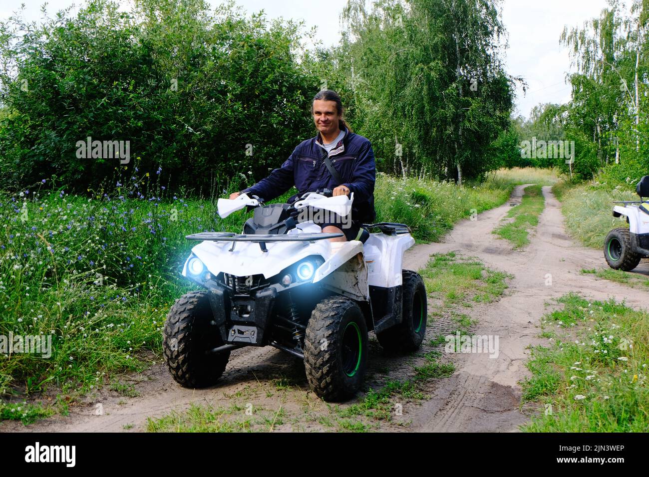 Happy man on the ATV Quad Bike in the wood Stock Photo - Alamy