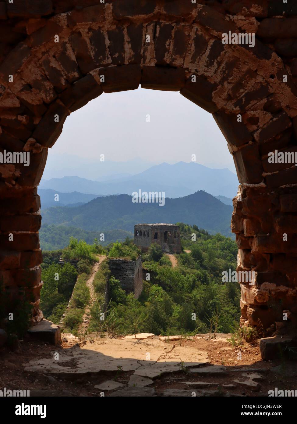 A ruin on top of a hill seen from a stone arch building Stock Photo - Alamy