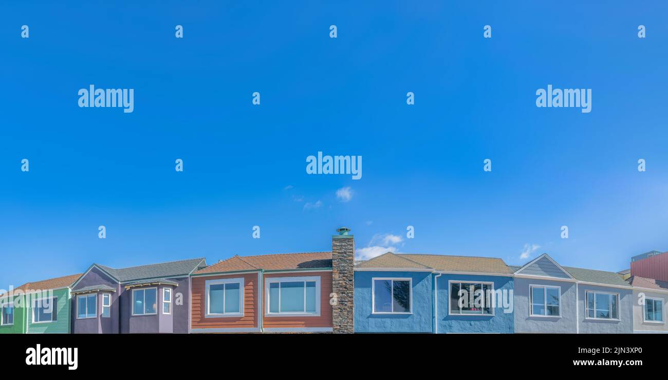 Colorful adjacent suburban houses below the clear sky at San Francisco ...
