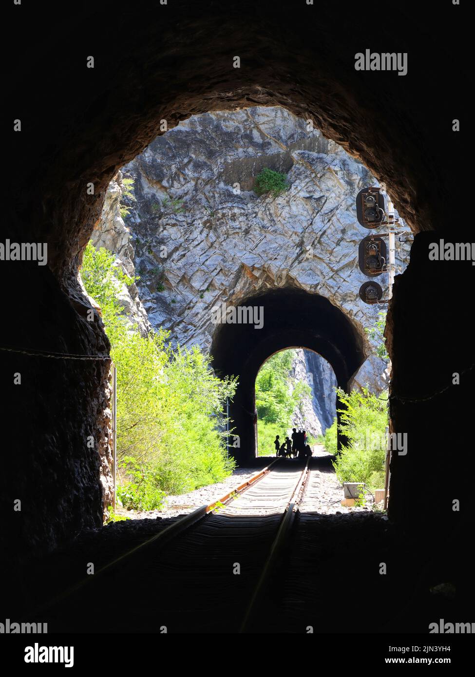 A group of people inside a dark rail tunnel Stock Photo - Alamy