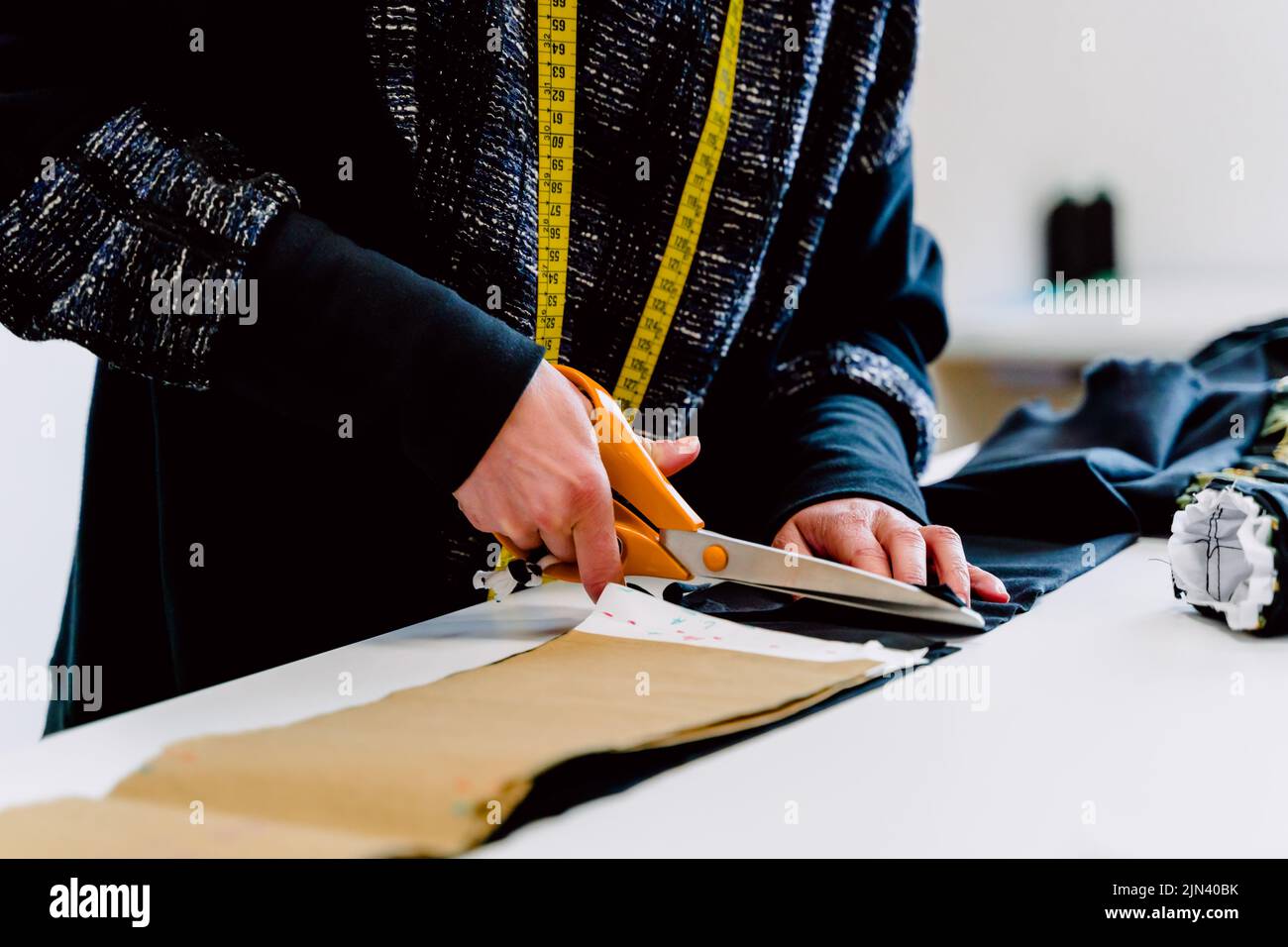 Dressmaker with scissors cutting cloth Stock Photo - Alamy
