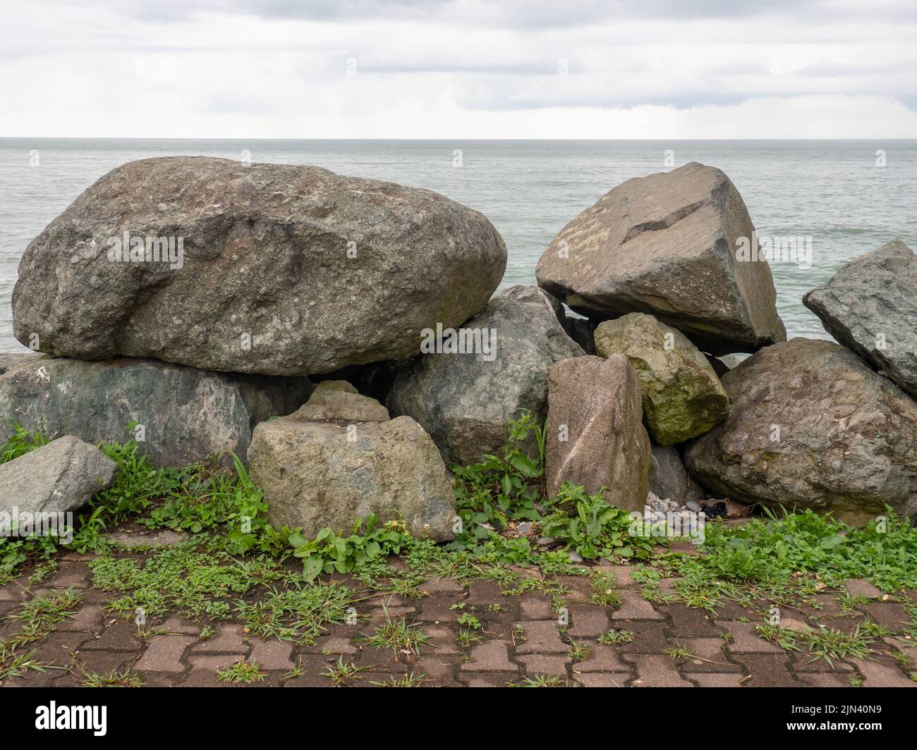 Barrier of large stones on the seashore. Wave protection. Irregular ...