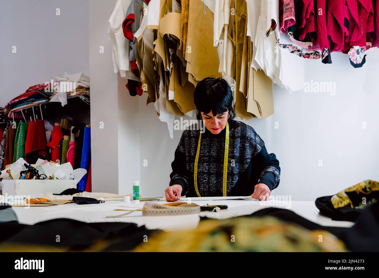 Dressmaker woman measuring the garments to design them Stock Photo - Alamy