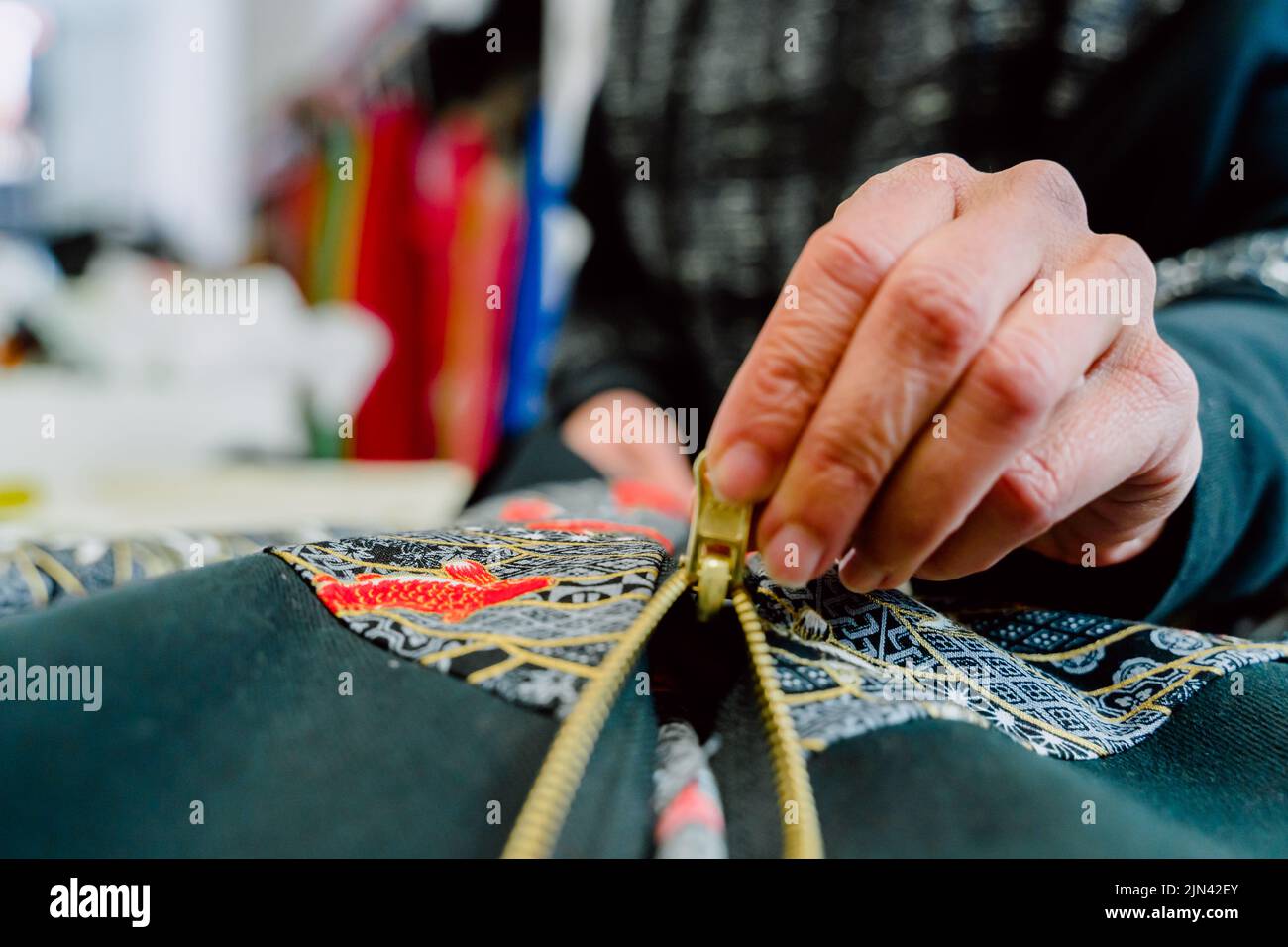 Designer zipping up the zipper she just sewed Stock Photo - Alamy