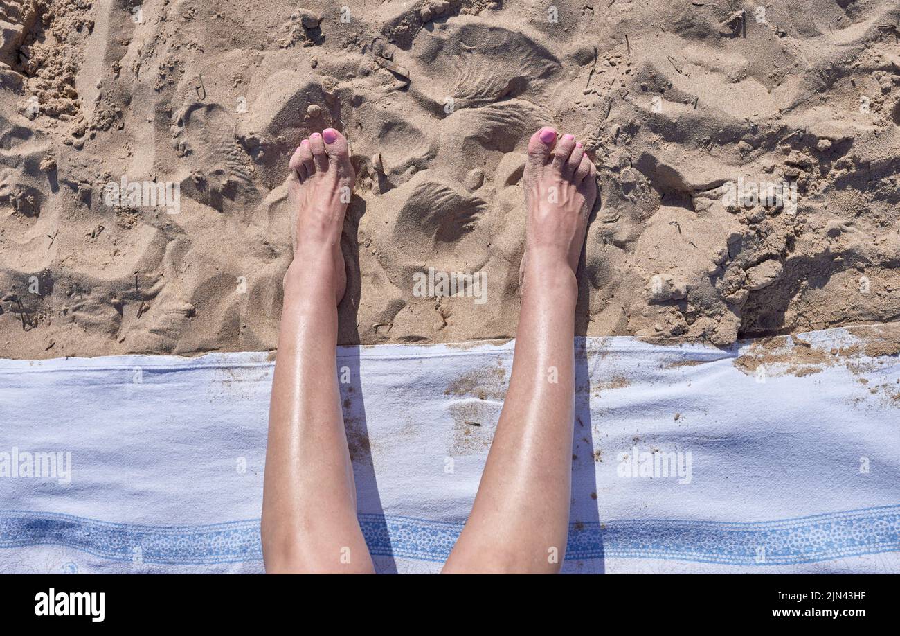 detail of a woman's legs sunbathing on a towel at the beach Stock Photo ... detail of a woman's legs sunbathing on a towel at the beach Stock Photo ...