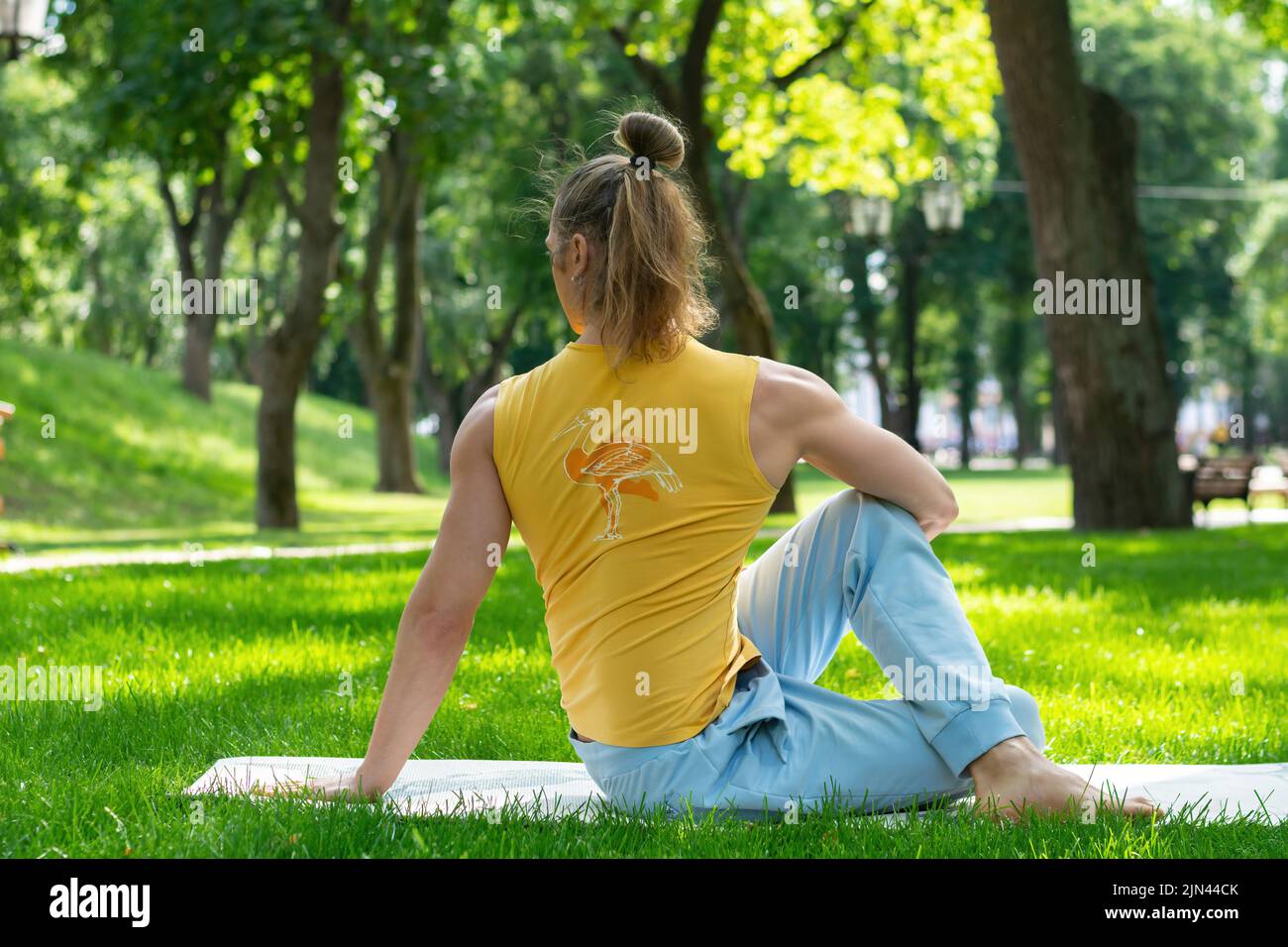 Young man practice yoga in the park. Yoga asanas in city park, sunny ...