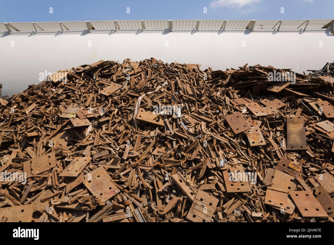 Pile of discarded ferous metal with tanker railcar in background at ...