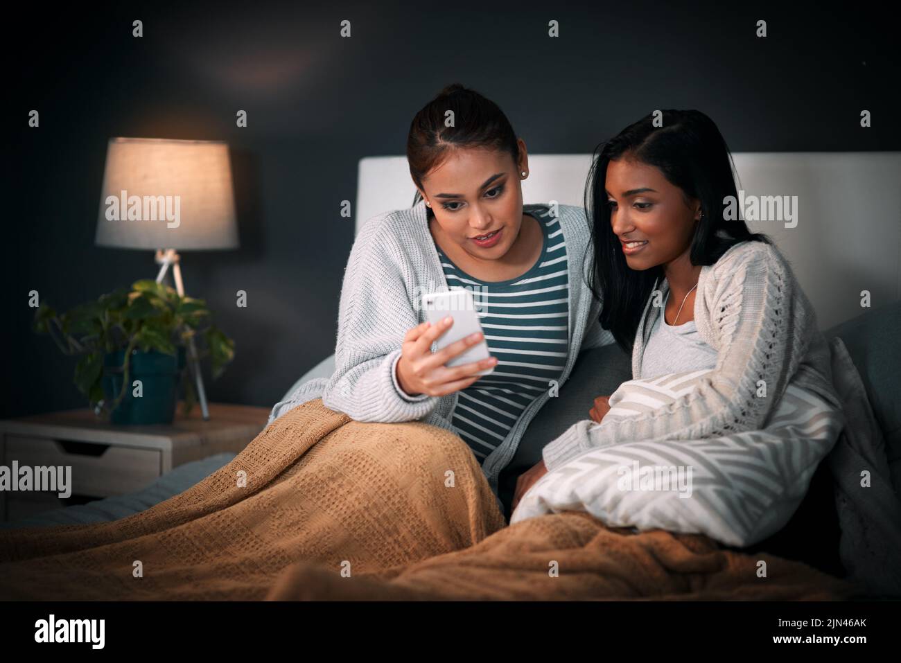 Do you think thats his new girlfriend. a young woman showing her friend ...