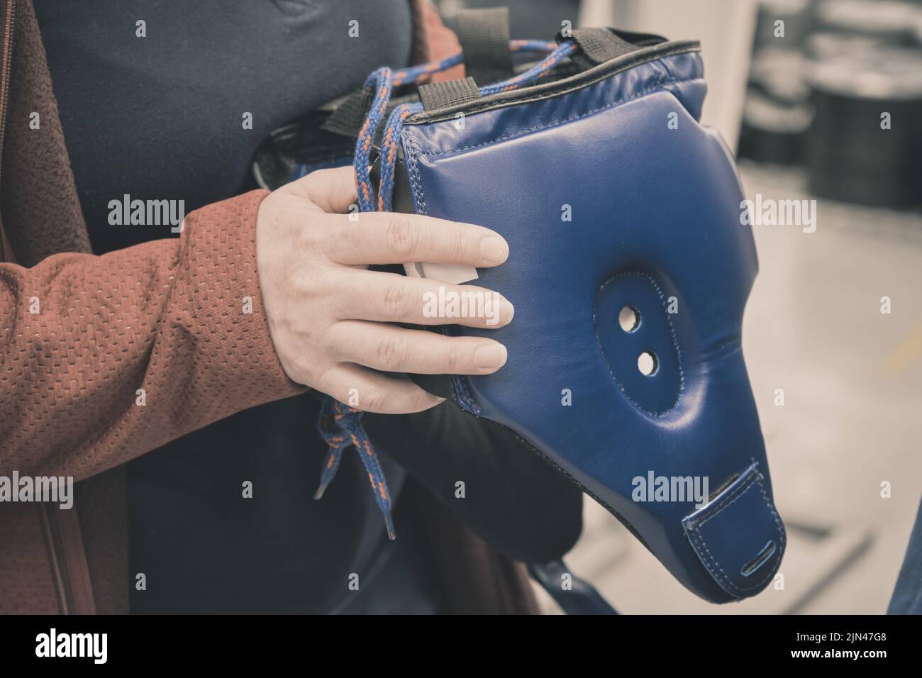 Woman in store chooses blue helmet to boxing to buy. Hands close up ...